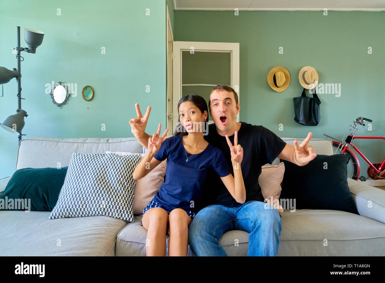 Happy couple, fun together showing peace sign Stock Photo - Alamy
