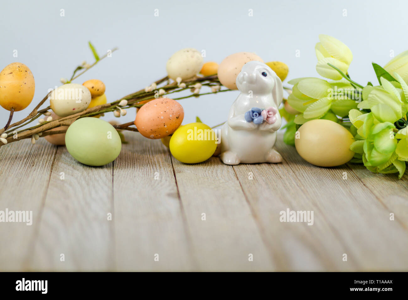 Spring Easter background on wooden board with white ceramic rabbit and ...
