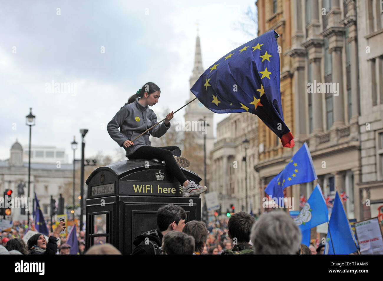 A protestor waves the flag of Europe from the top of a phone bix during ...