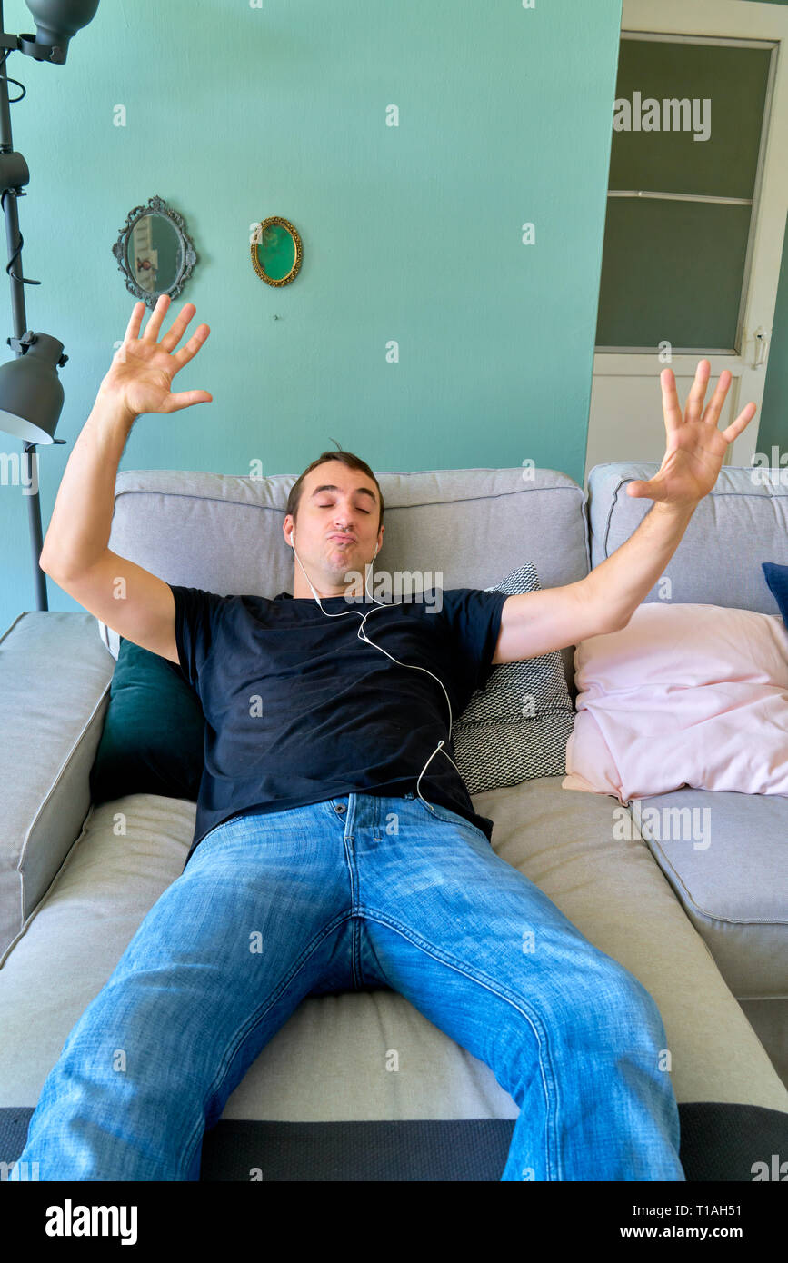 Handsome guy posing - lying down, feel the music with raised hand Stock ...