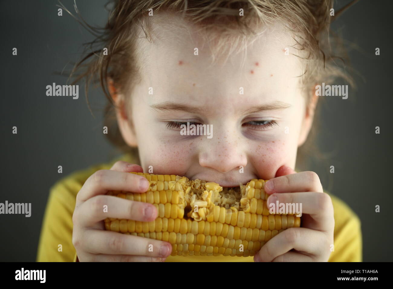 Boy eating sweet corn Stock Photo - Alamy