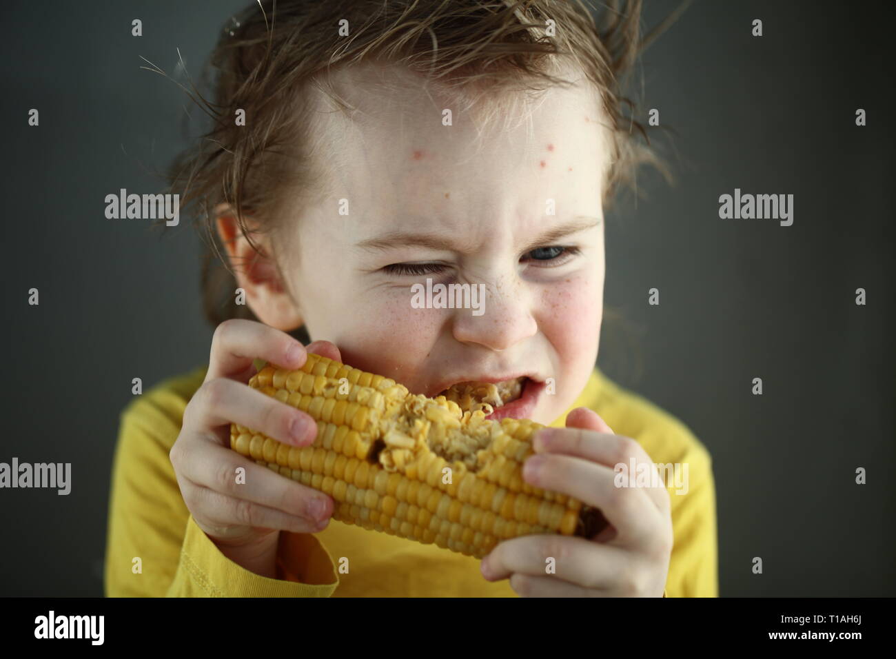 Boy eating sweet corn Stock Photo - Alamy