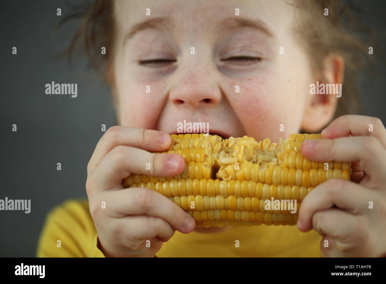 Boy eating sweet corn Stock Photo - Alamy