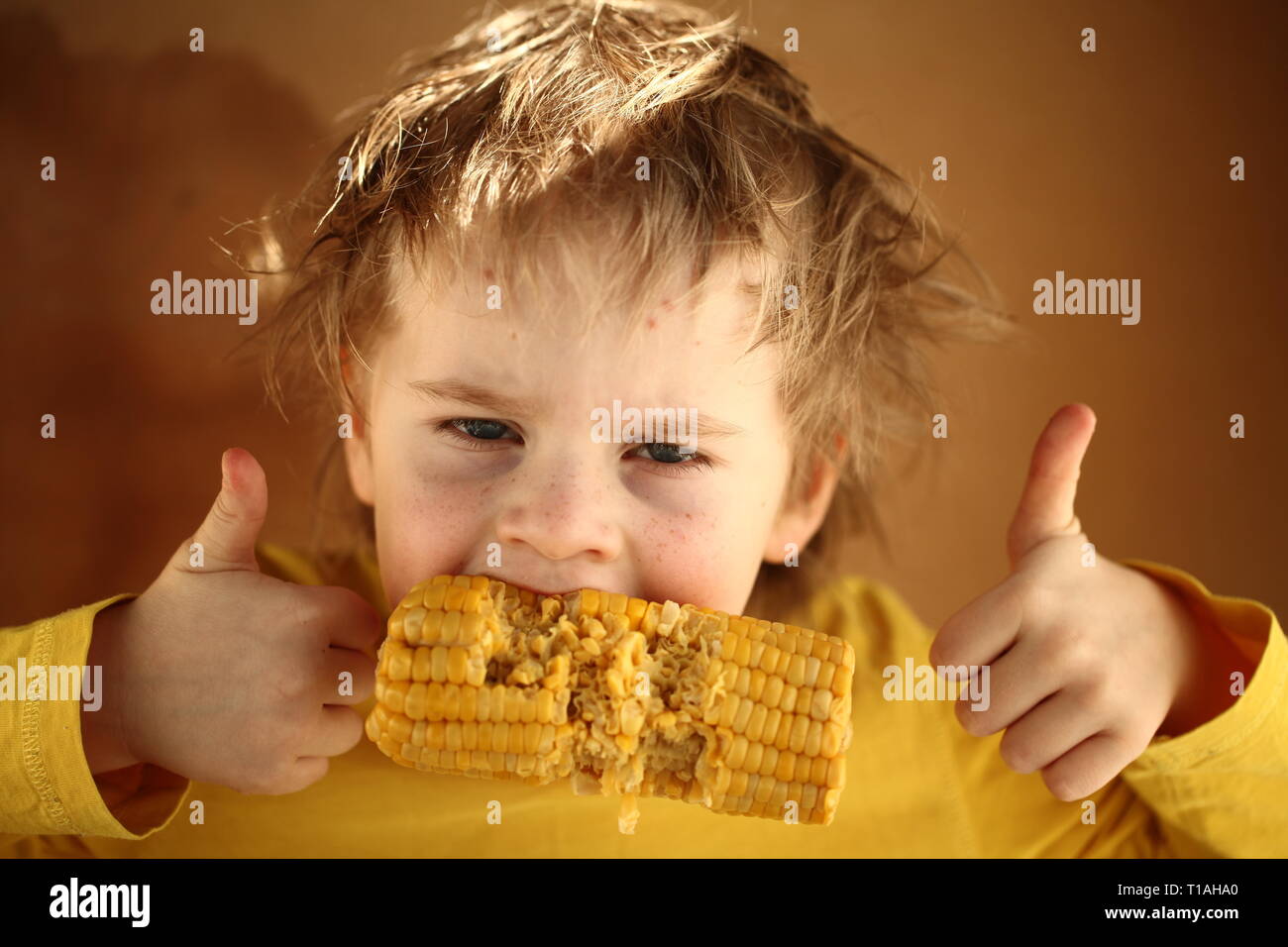 Boy eating sweet corn Stock Photo - Alamy