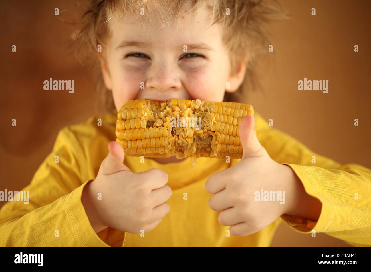 Boy eating sweet corn Stock Photo - Alamy