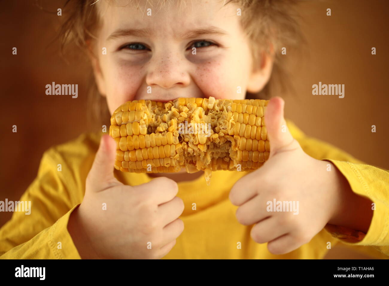 Boy eating sweet corn Stock Photo - Alamy