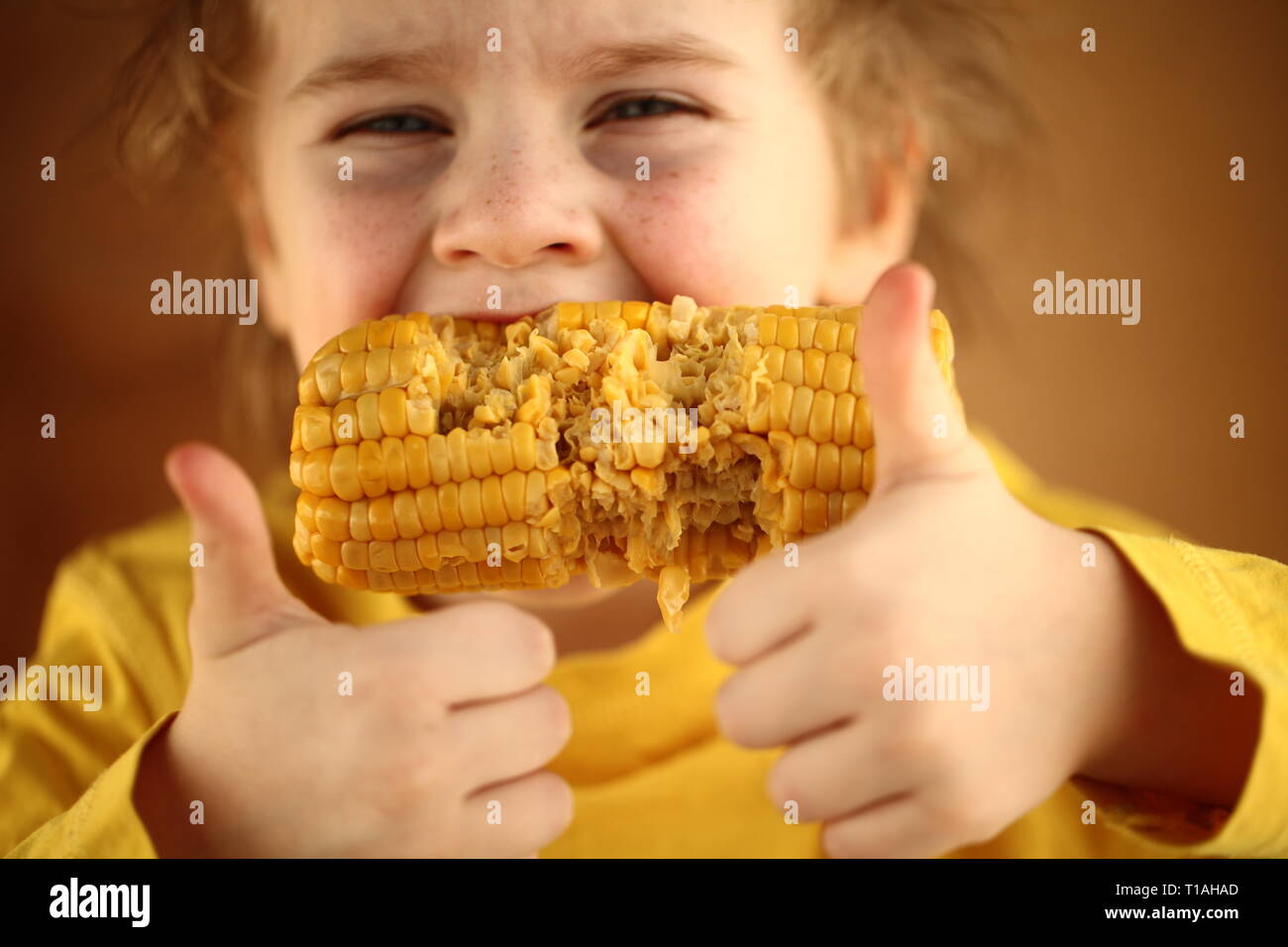 Boy eating sweet corn Stock Photo - Alamy