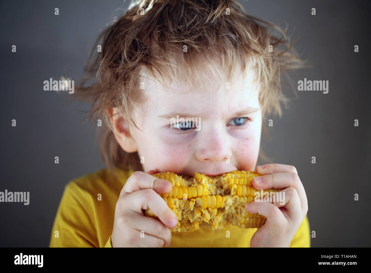 Boy eating sweet corn Stock Photo - Alamy