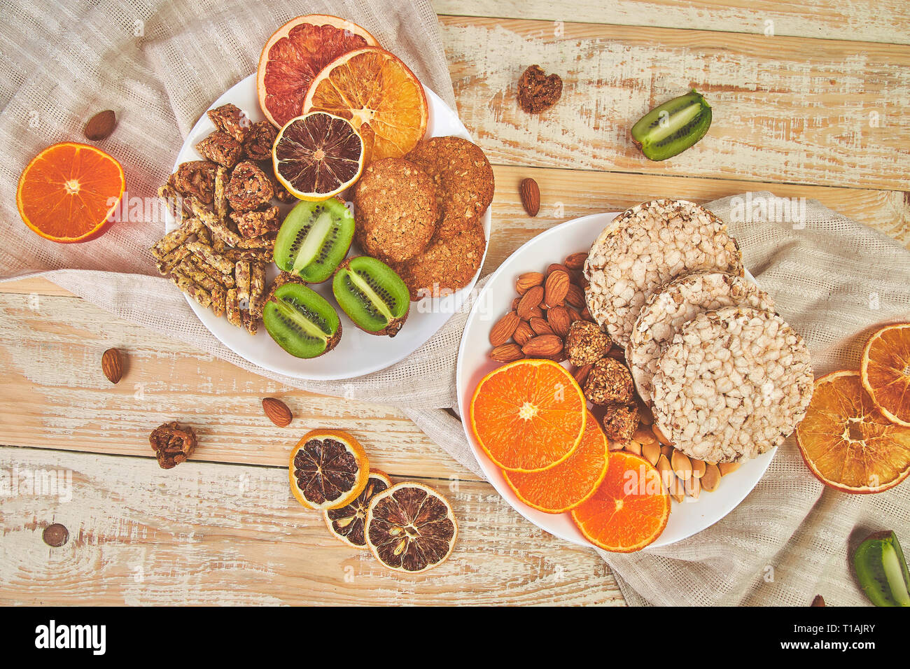 Healthy snacks on white plates - variety oat granola bar, rice crips ...