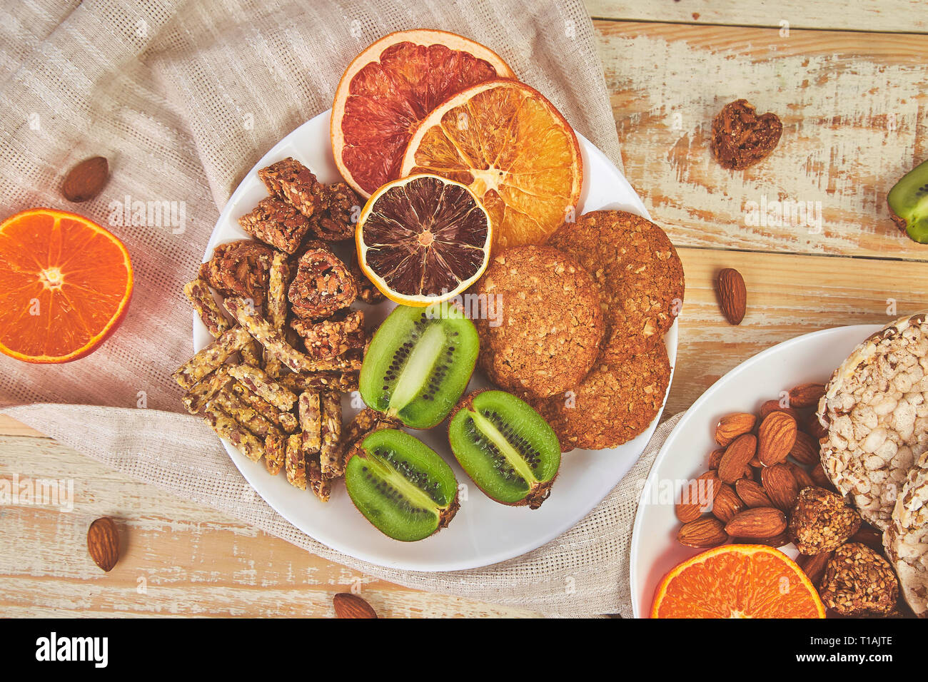 Healthy snacks on white plates - variety oat granola bar, rice crips ...