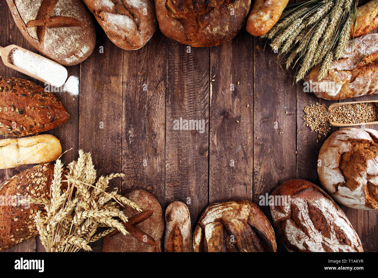 Different kinds of bread and bread rolls on board from above. Kitchen ...