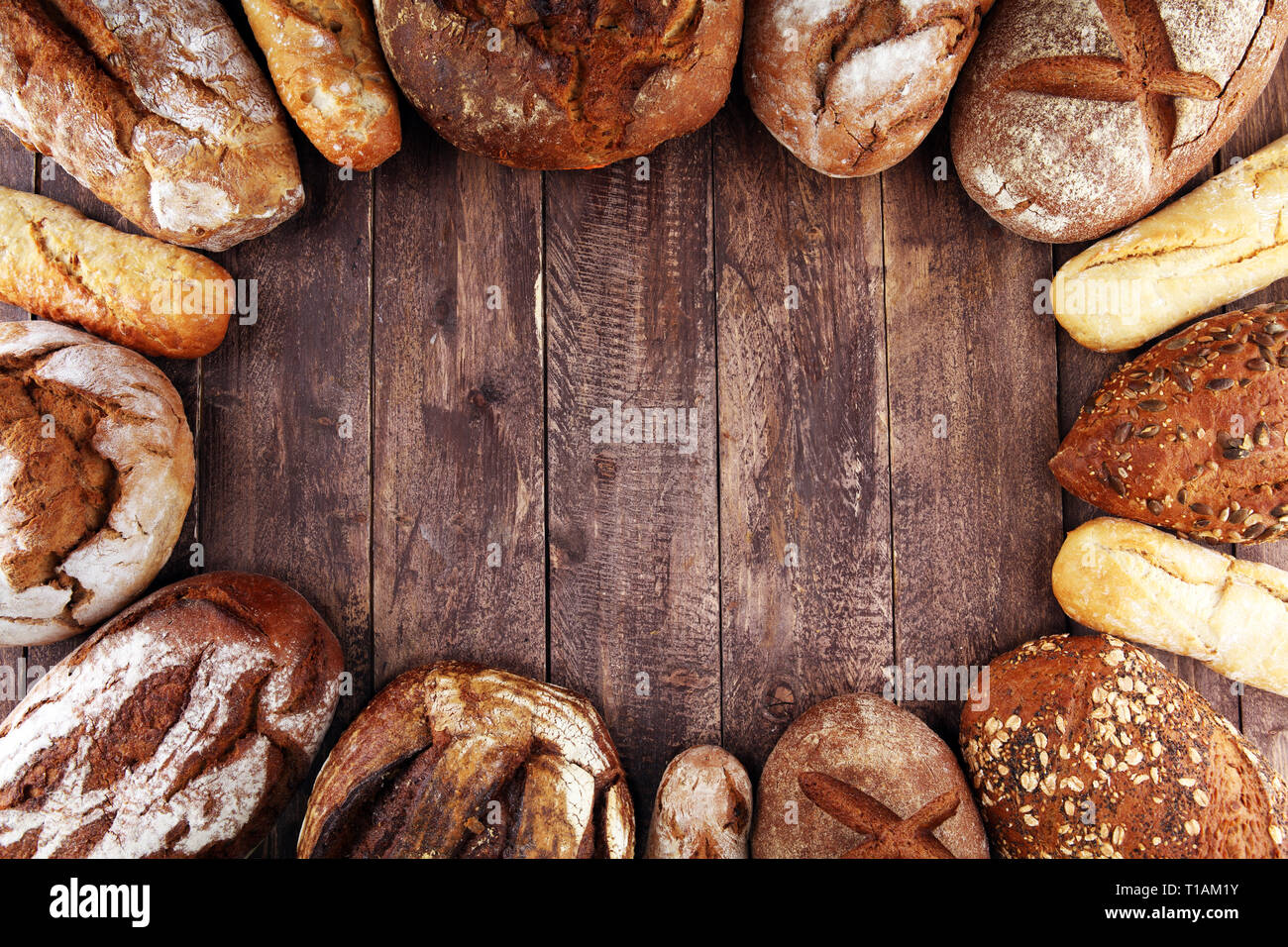 Different kinds of bread and bread rolls on board from above. Kitchen ...