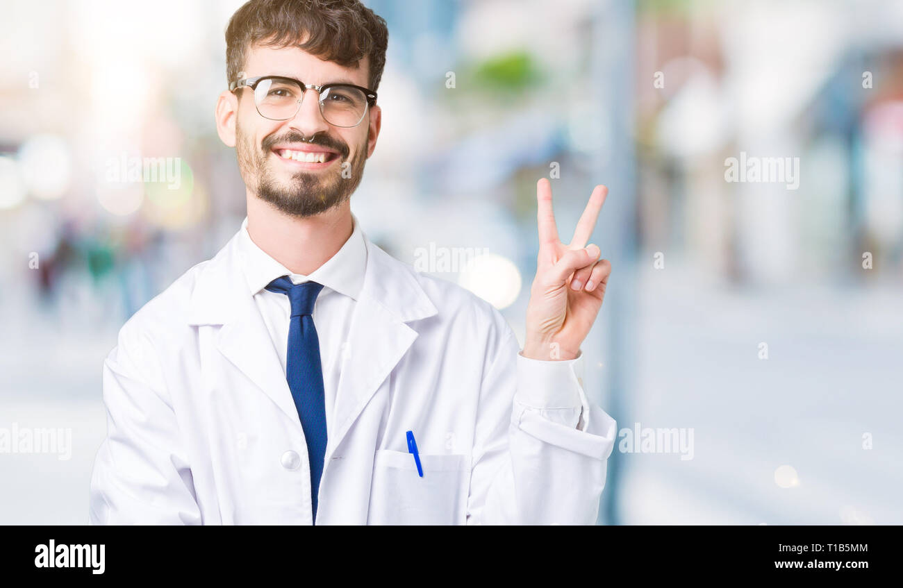 Young professional scientist man wearing white coat over isolated ...