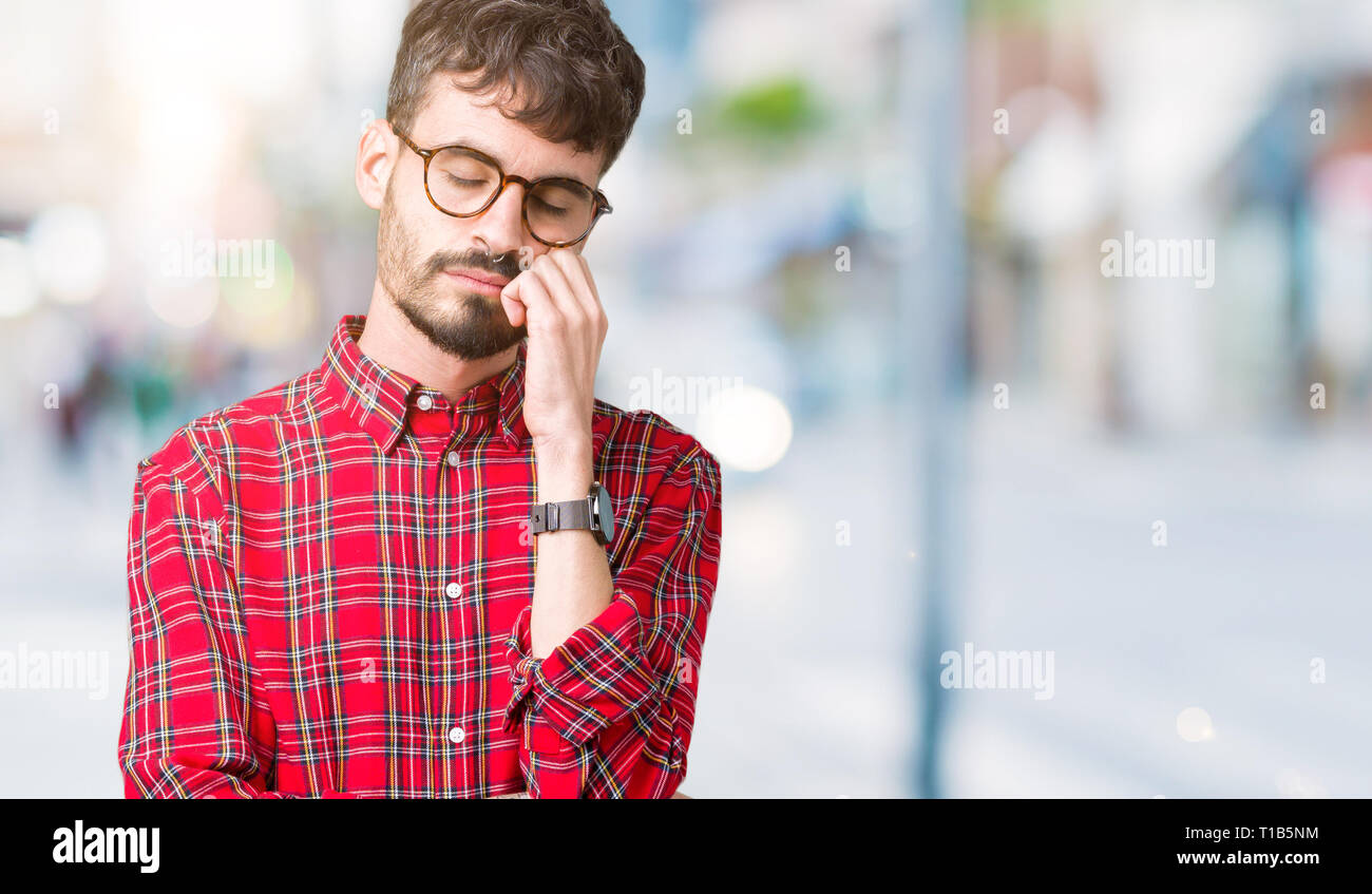 Young handsome man wearing glasses over isolated background thinking ...