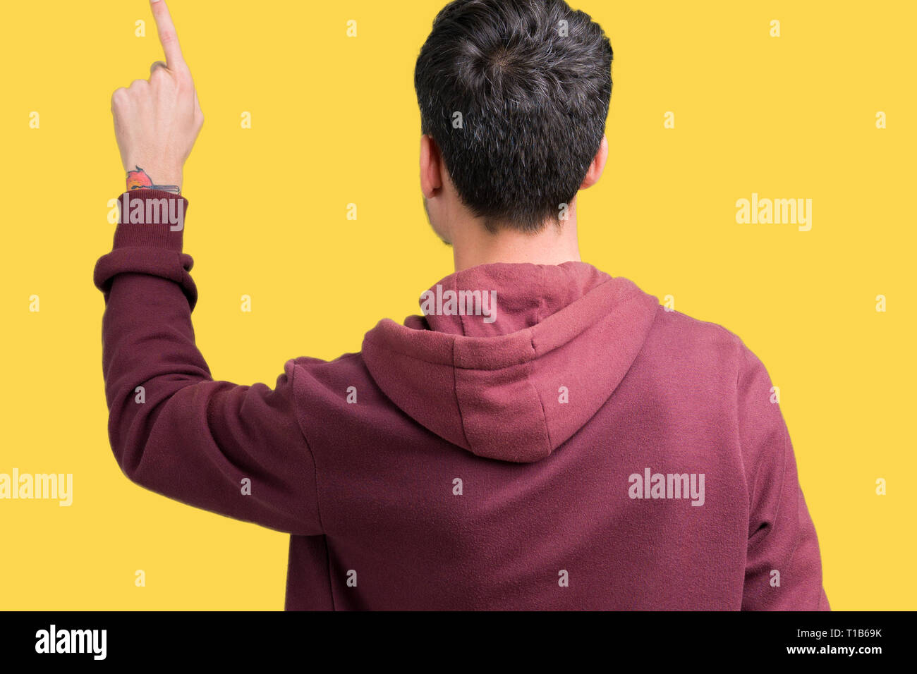 Young handsome man over isolated background Posing backwards pointing ...