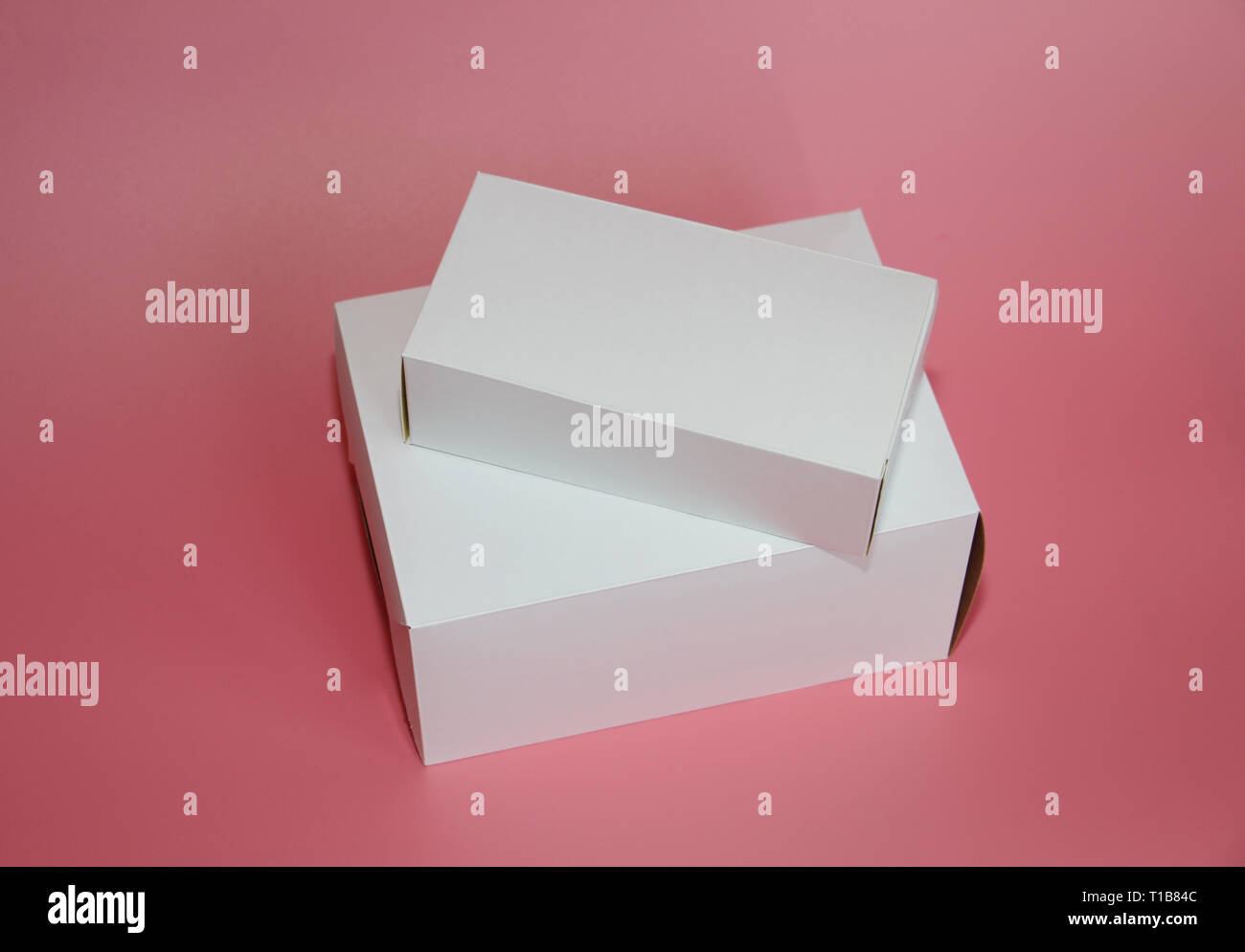 Two white boxes on a pink background. The boxes are on top of each ...