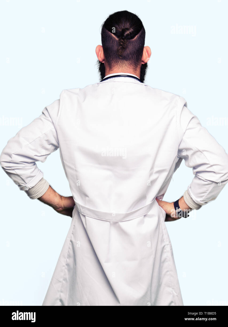 Young blond doctor man with beard wearing medical coat standing ...
