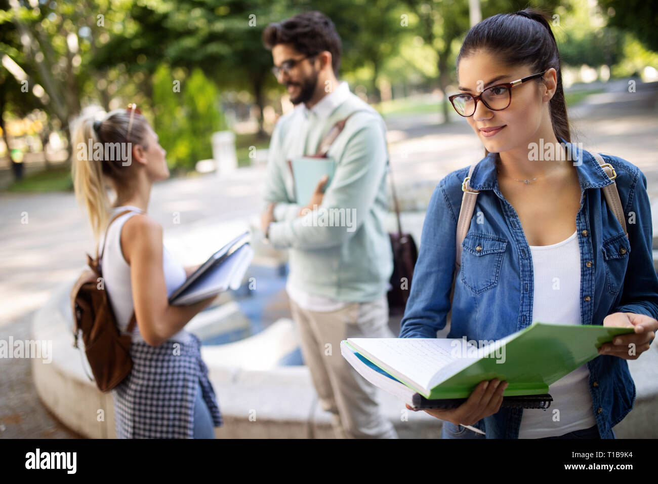 Happy young university students friends studying with books at ...