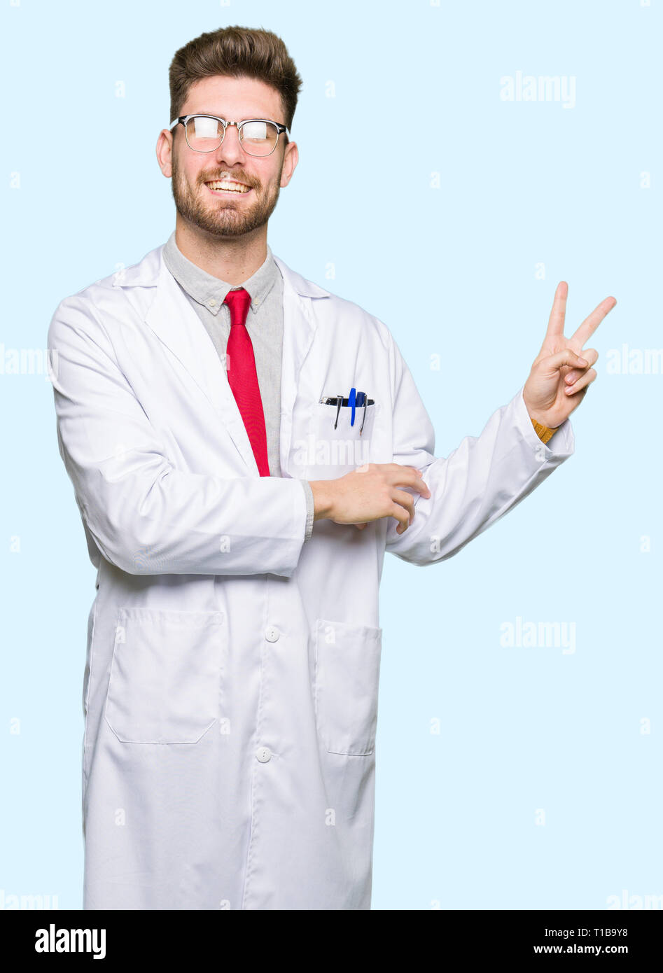 Young handsome scientist man wearing glasses smiling with happy face ...