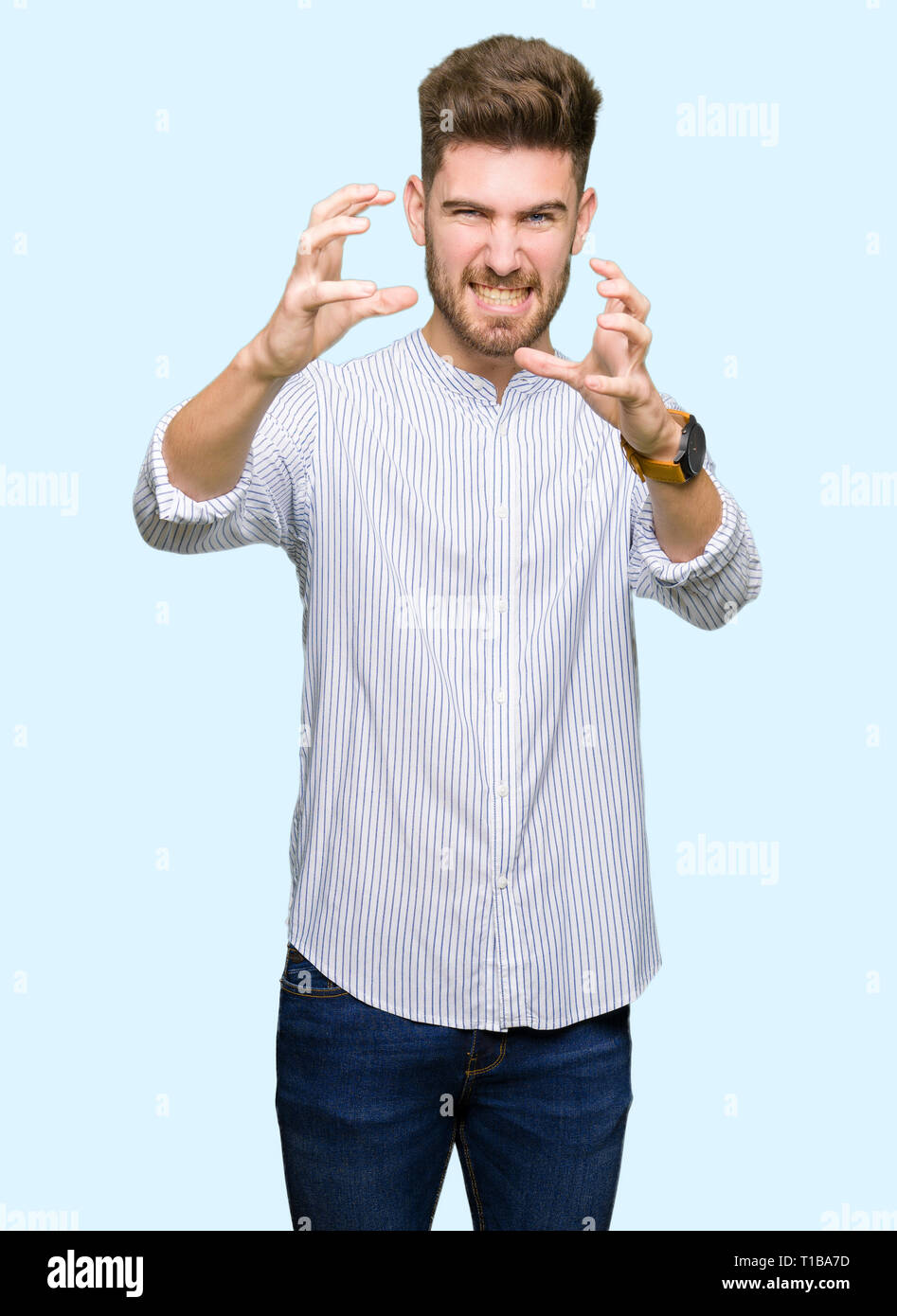 Young handsome man Shouting frustrated with rage, hands trying to ...