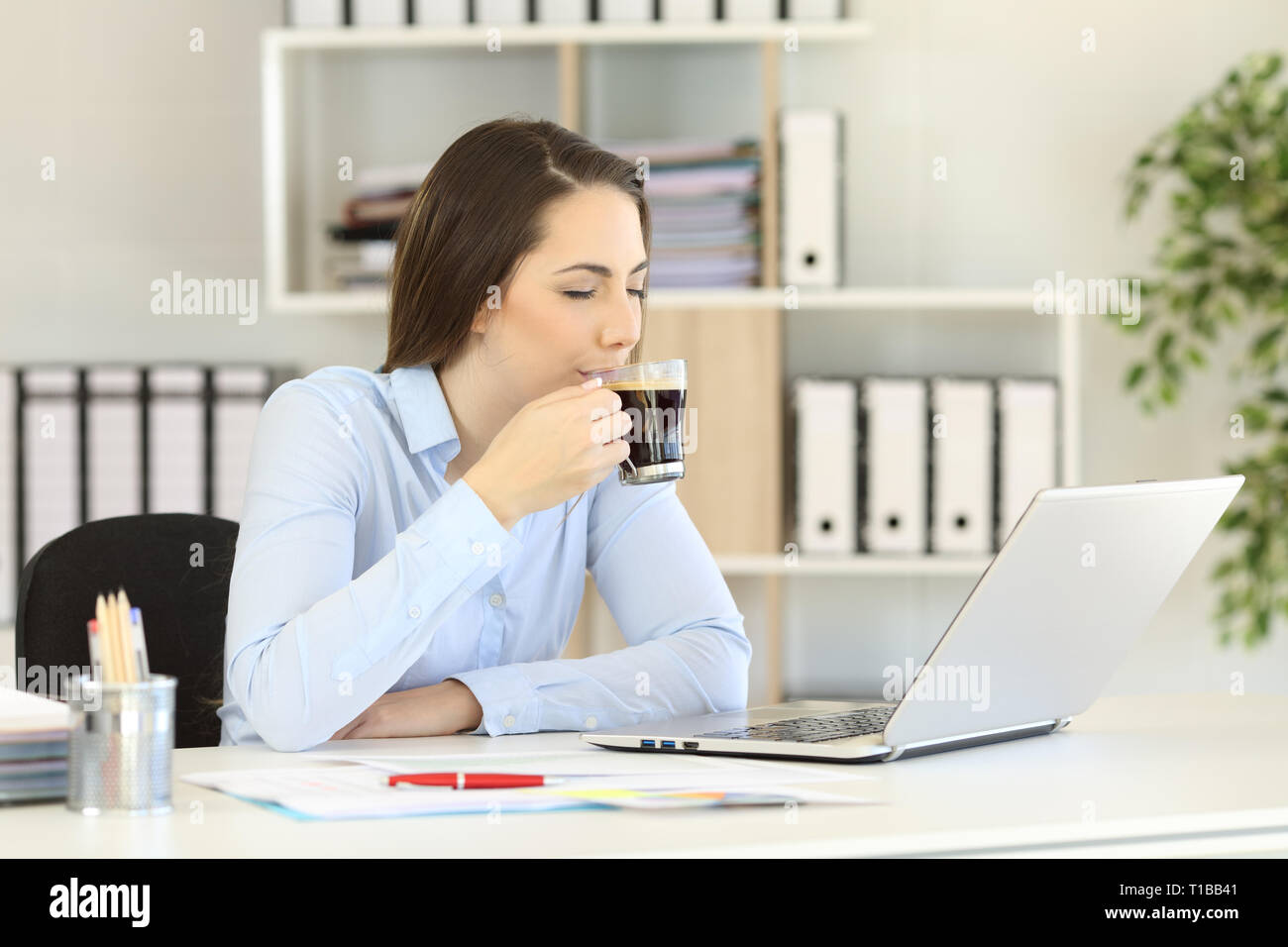 Office worker relaxing drinking coffee enjoying flavour Stock Photo - Alamy