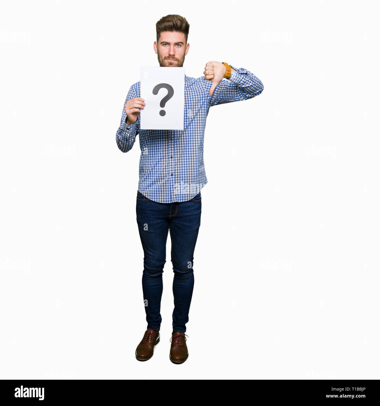 Young handsome man holding paper with question mark with angry face ...