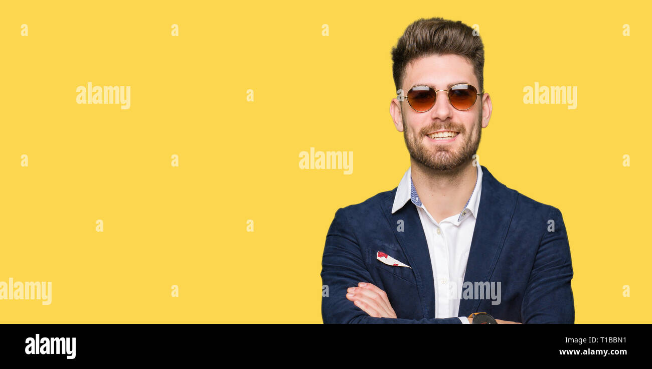 Young handsome elegant man wearing sunglasses and fashion blazer happy ...