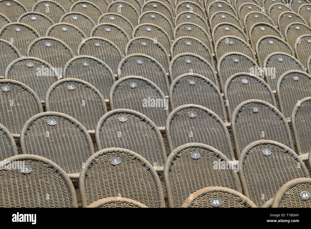 Rows of empty grey brown wicker seats in open air concert hall ...