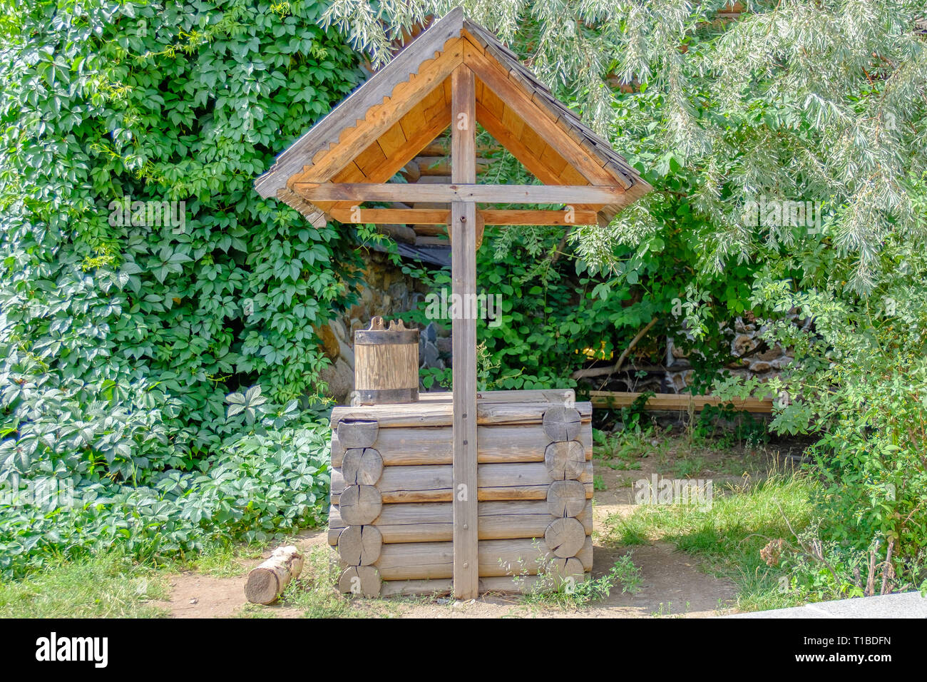 Old wooden well with bucket in rustic style Stock Photo - Alamy