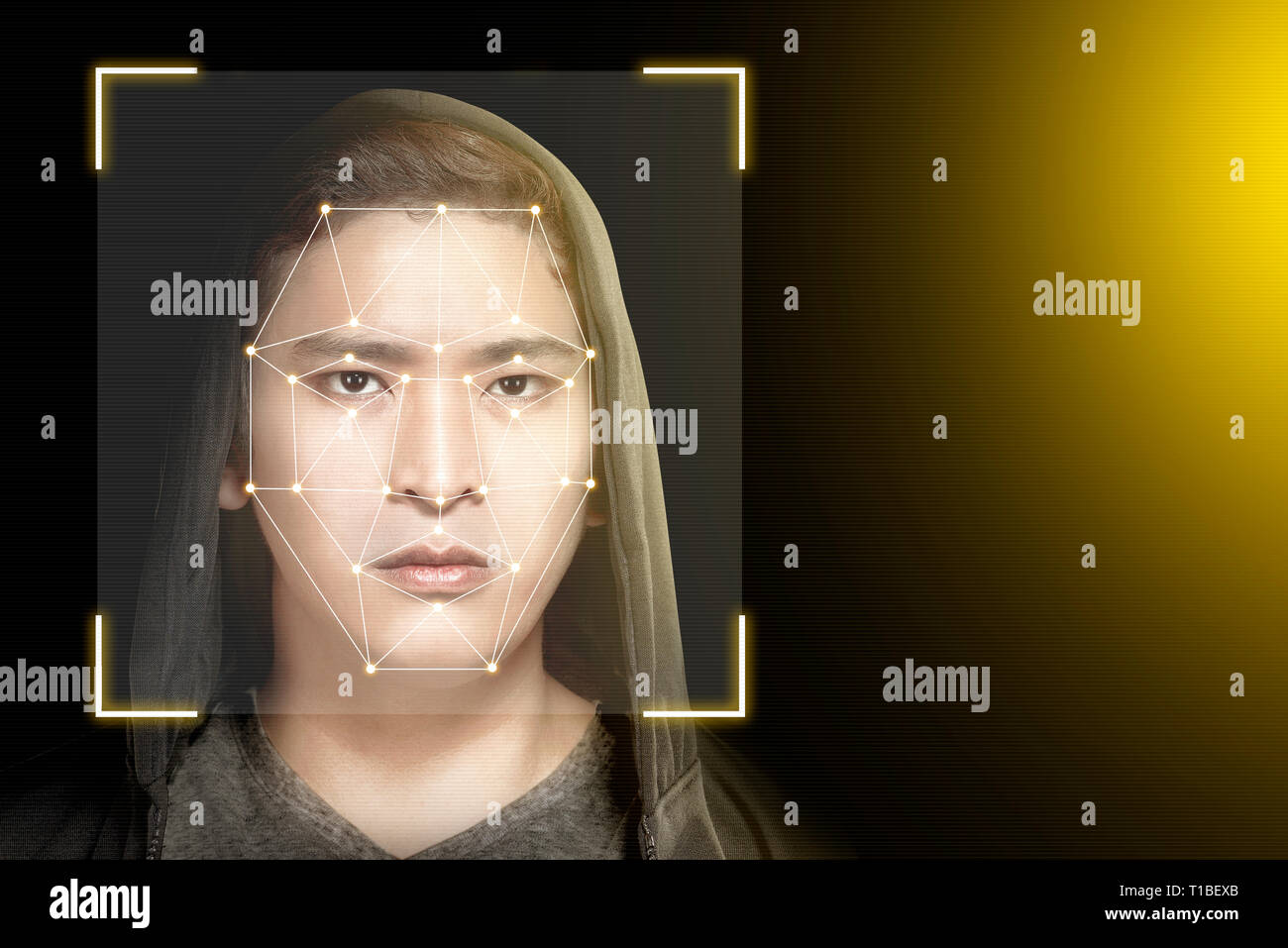 Young asian man in black hoodie using face recognition over dark ...