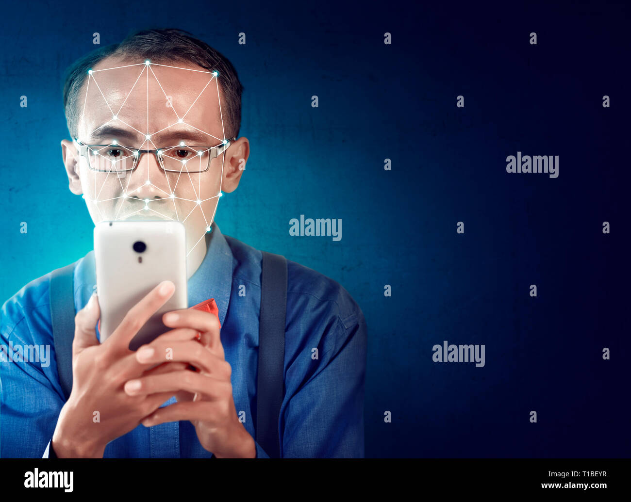 Attractive asian businessman with mobile phone using face recognition ...