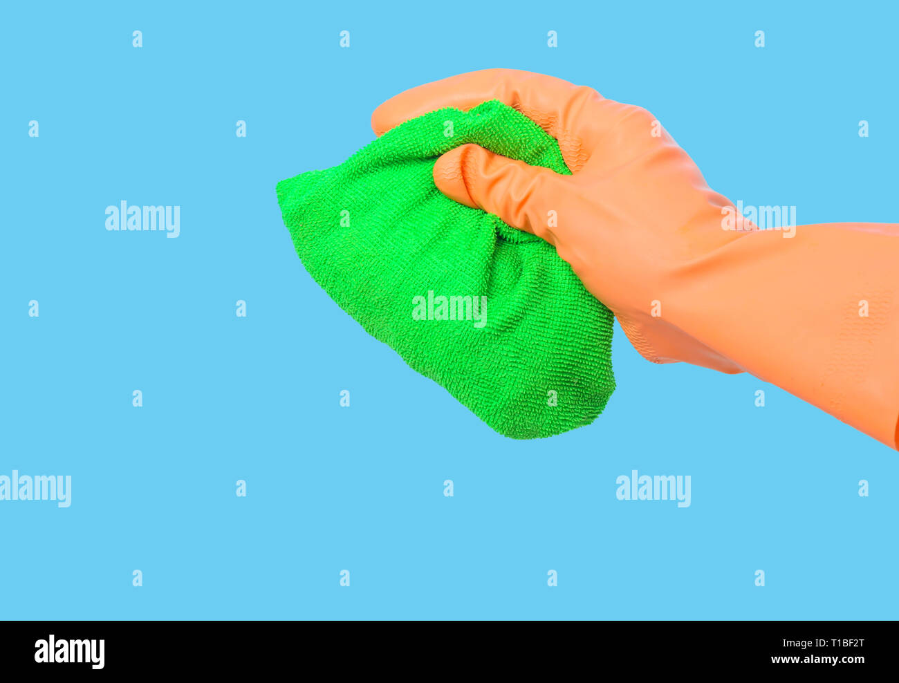 Hand holding green cleaning rag isolated on blue Stock Photo - Alamy