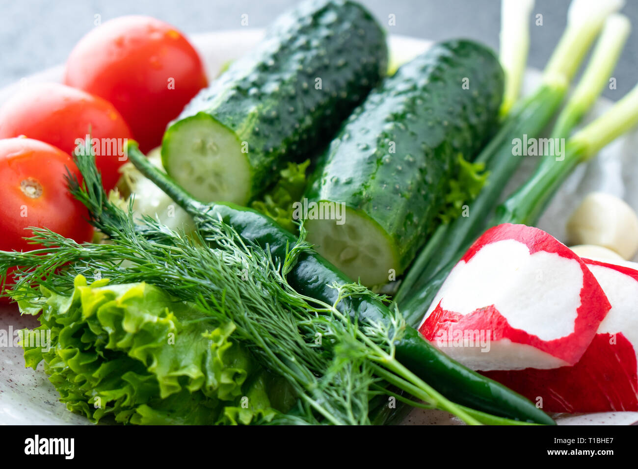 cucumber, tomato, radish, parsley, onion and other vegetables on a ...