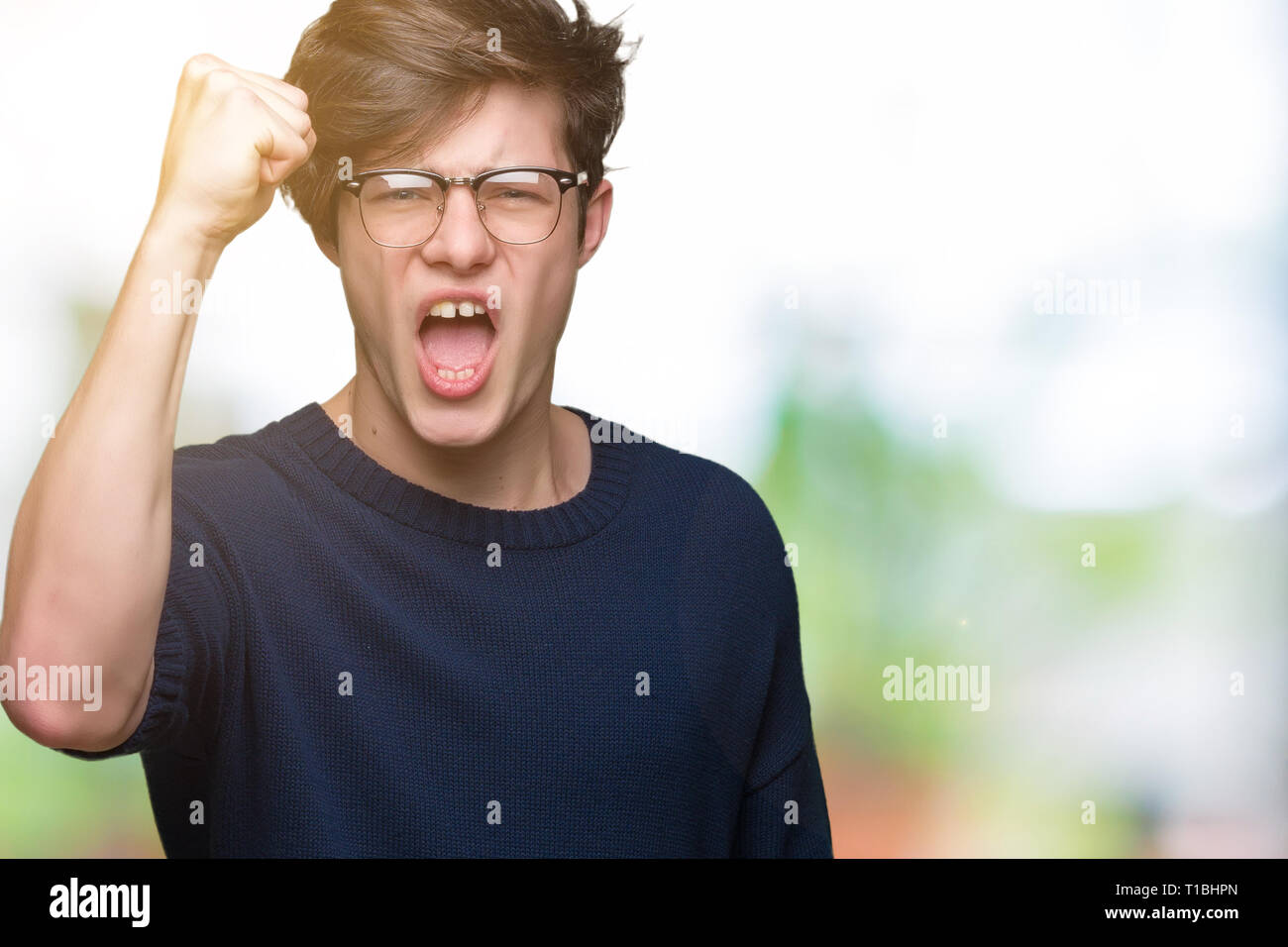 Young handsome man wearing glasses over isolated background angry and ...