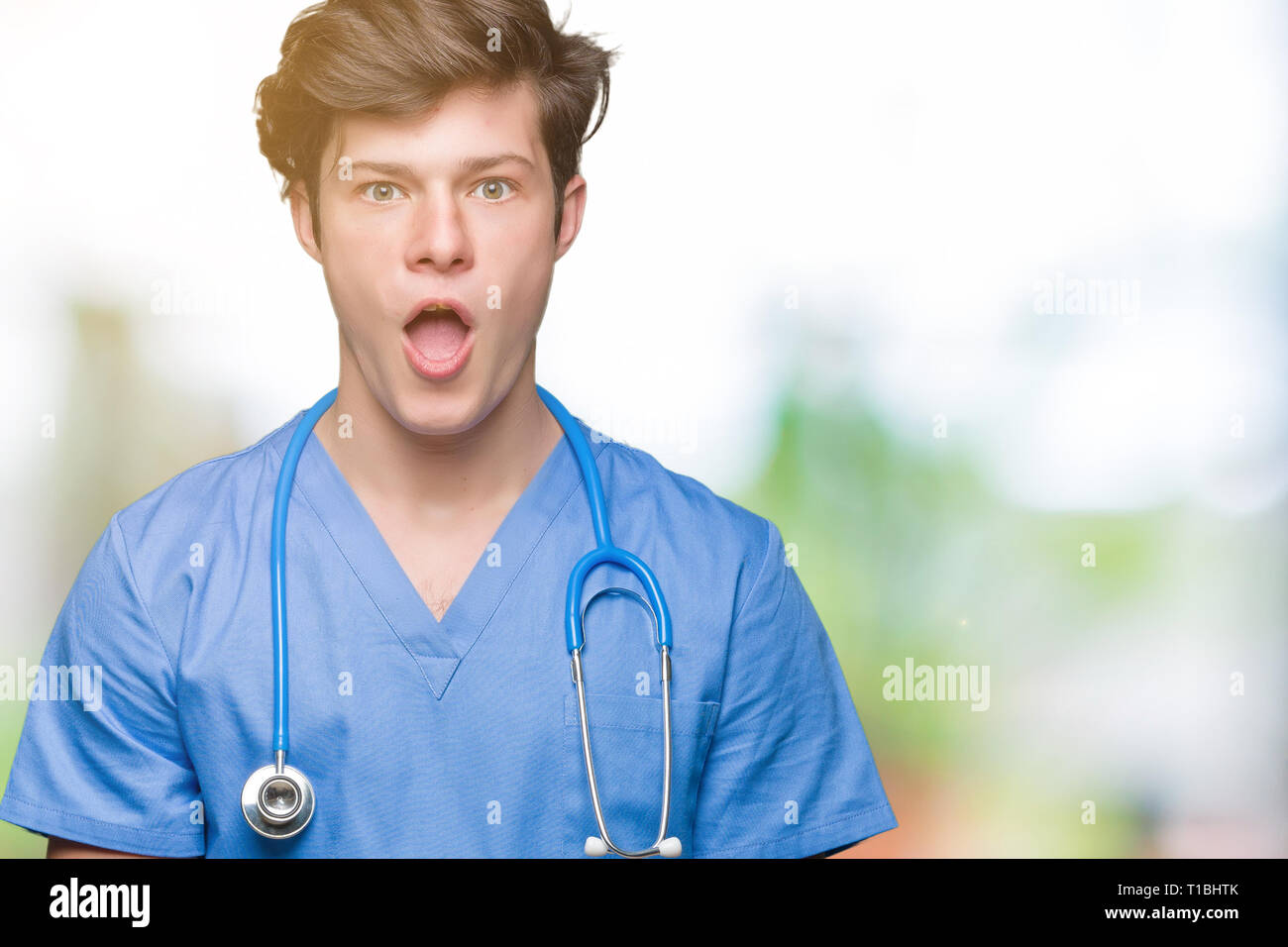 Young doctor wearing medical uniform over isolated background afraid ...