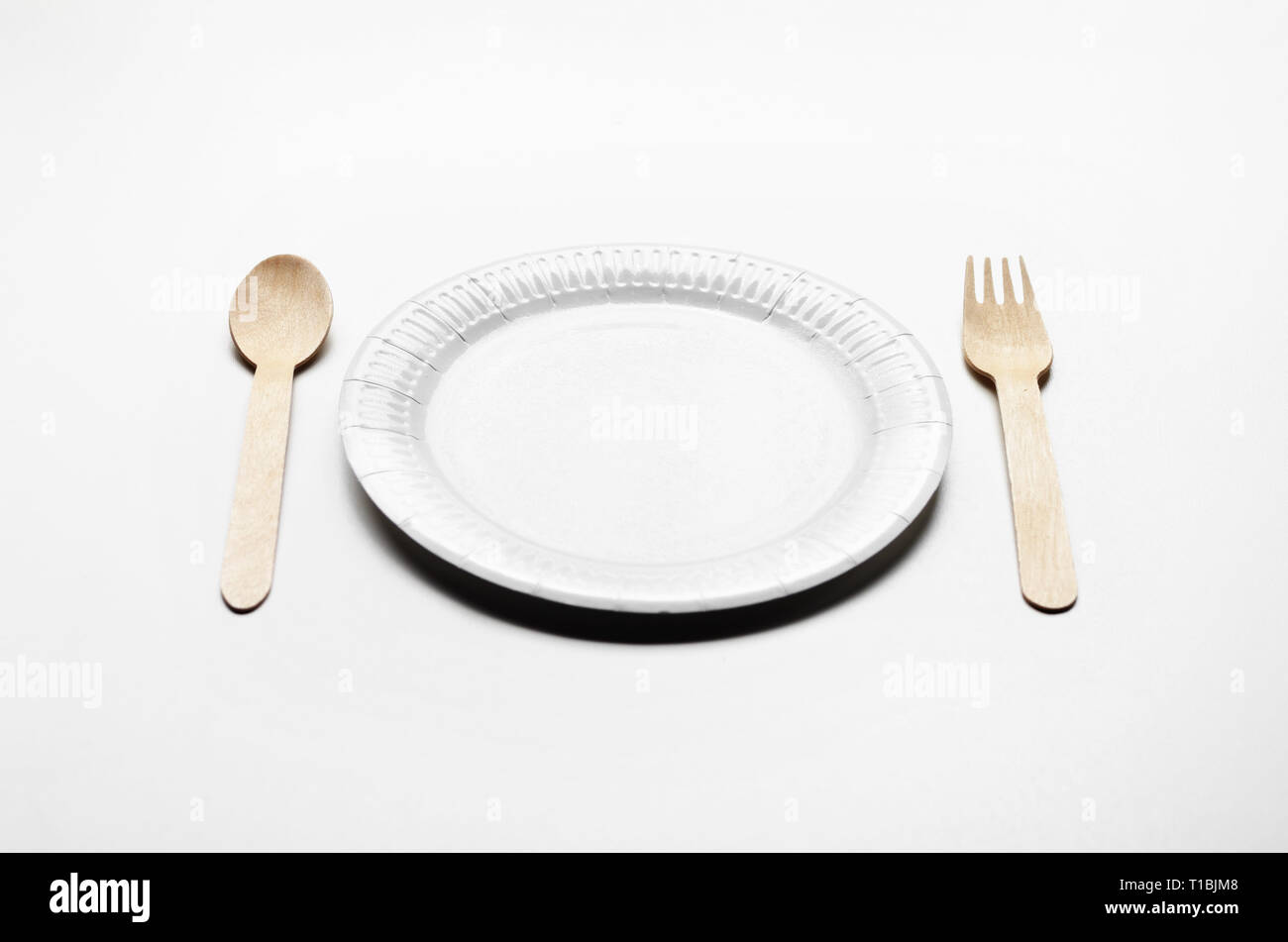 Wooden single use kitchenware and paper plate on white background Stock ...
