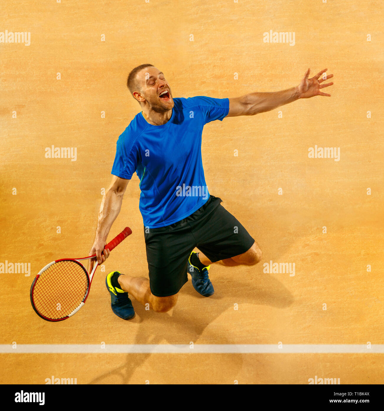 Portrait of a handsome male tennis player celebrating his success on a ...
