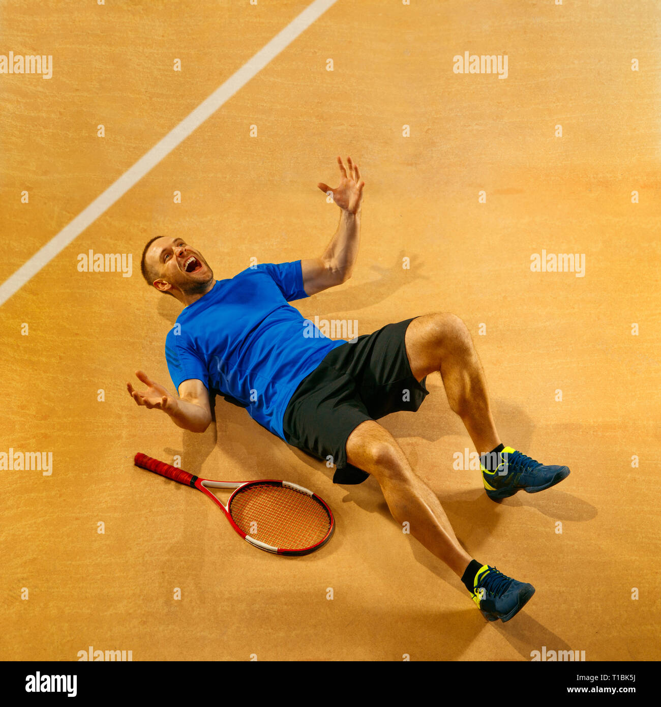 Portrait of a handsome male tennis player celebrating his success on a ...