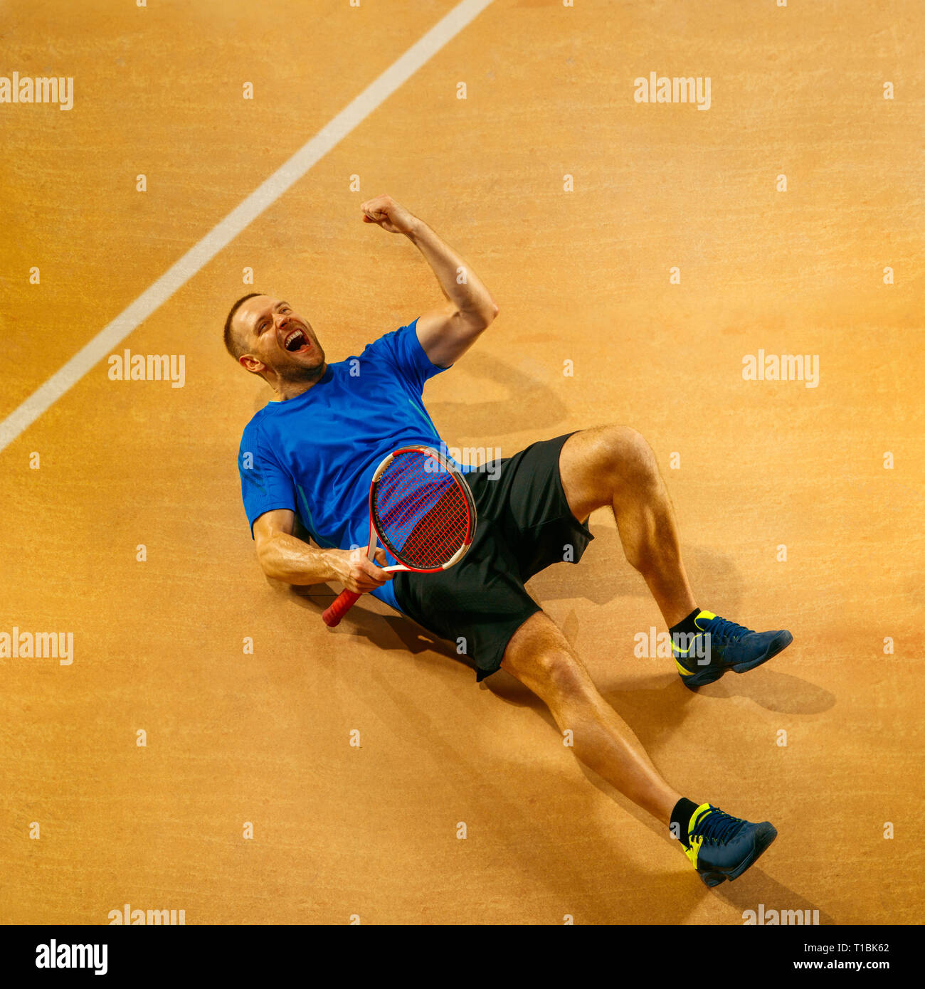 Portrait of a handsome male tennis player celebrating his success on a ...