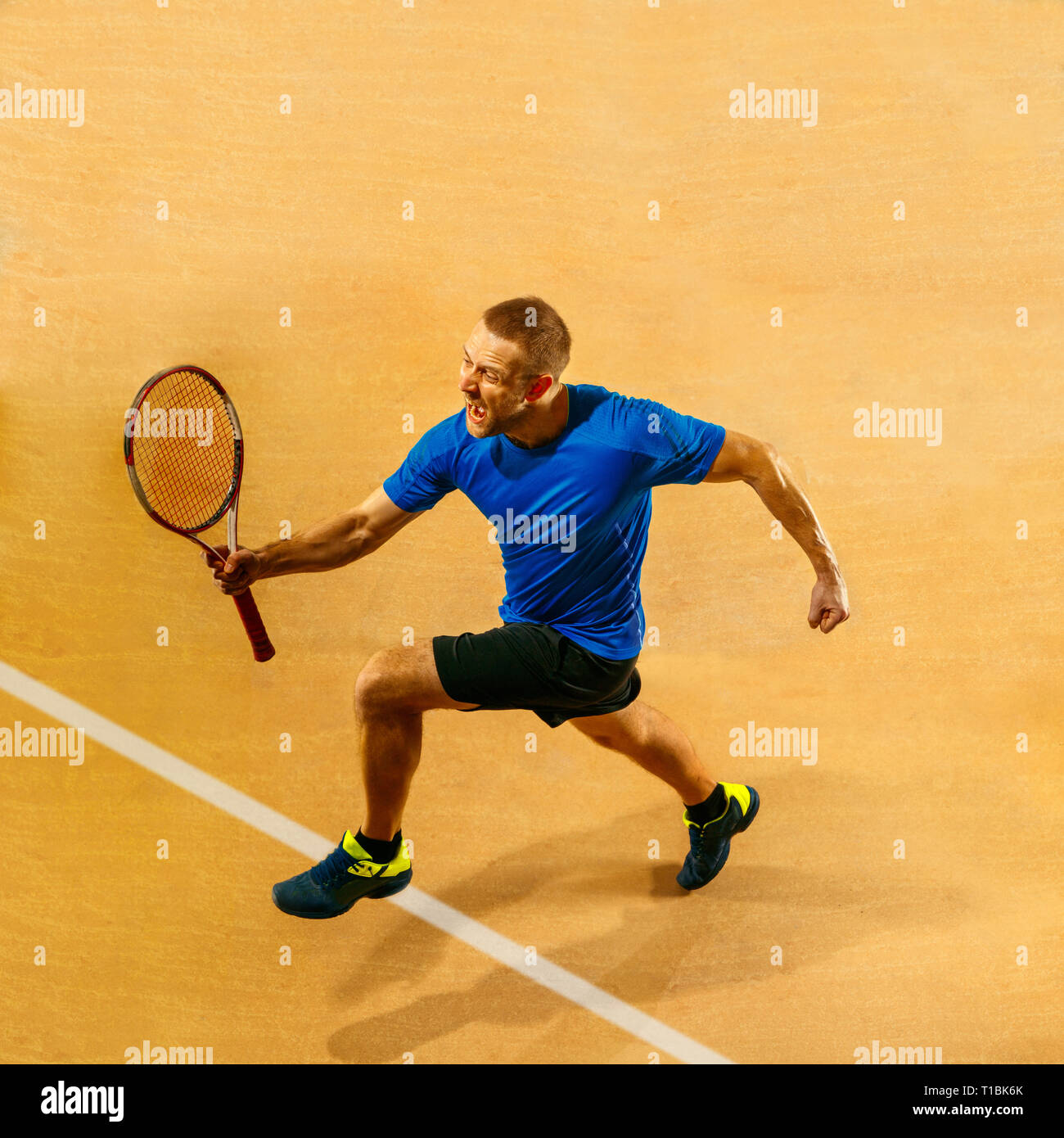 Portrait of a handsome male tennis player celebrating his success on a ...