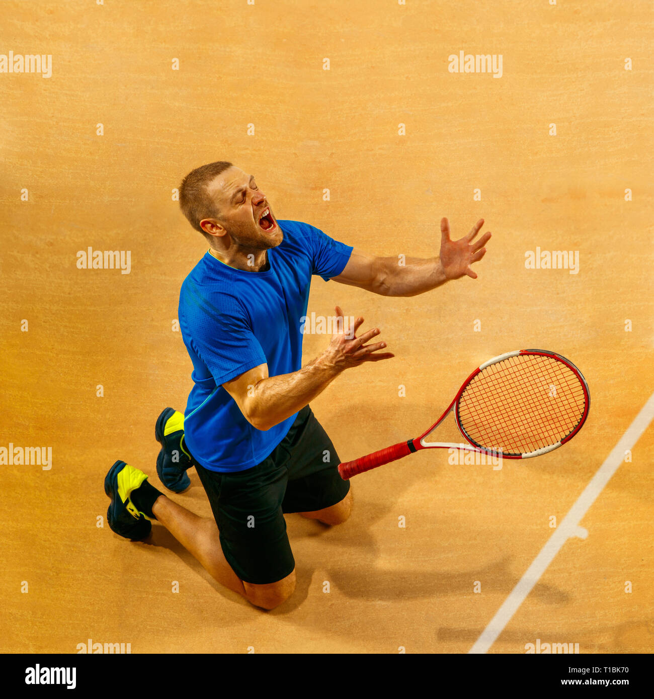 Portrait of a handsome male tennis player celebrating his success on a ...