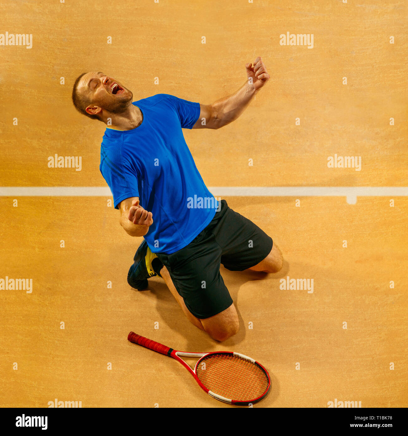 Portrait of a handsome male tennis player celebrating his success on a ...