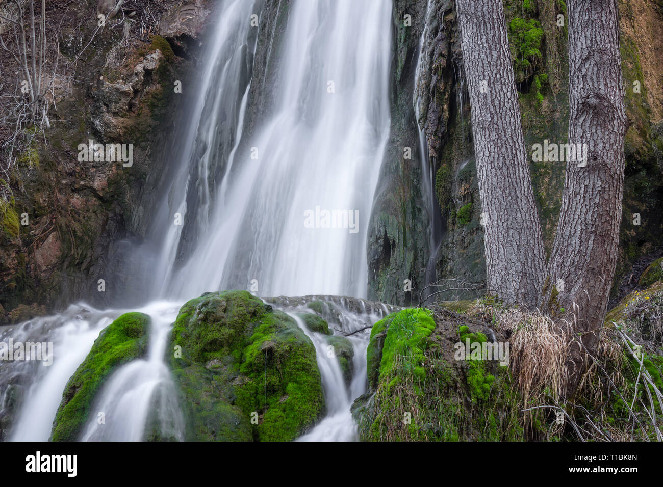Close up, long exposure view of a sunlit waterfall with soft streams of ...