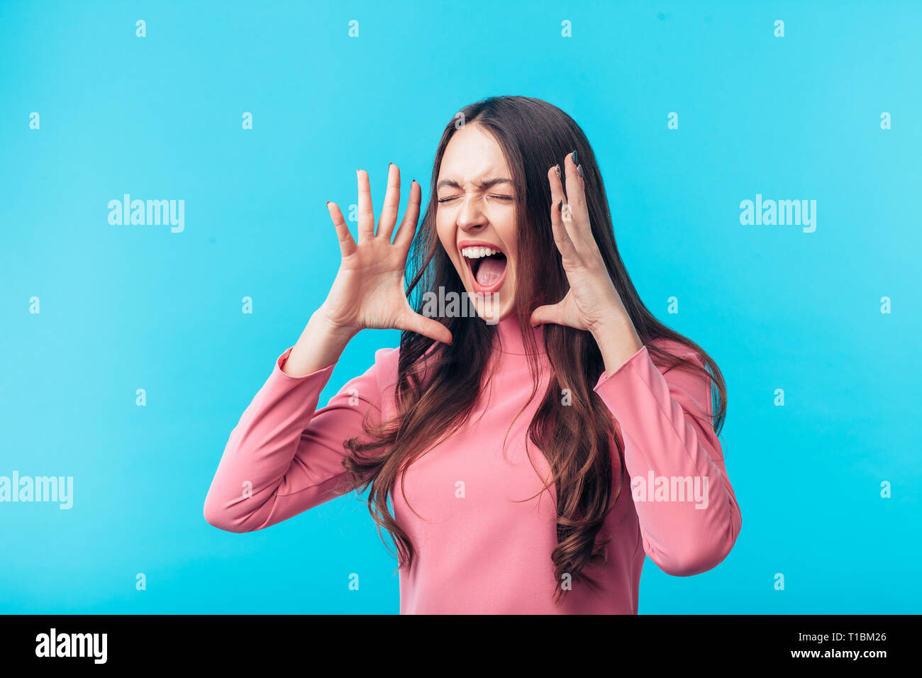 Shouting young angry woman isolated on blue background. Emotions ...
