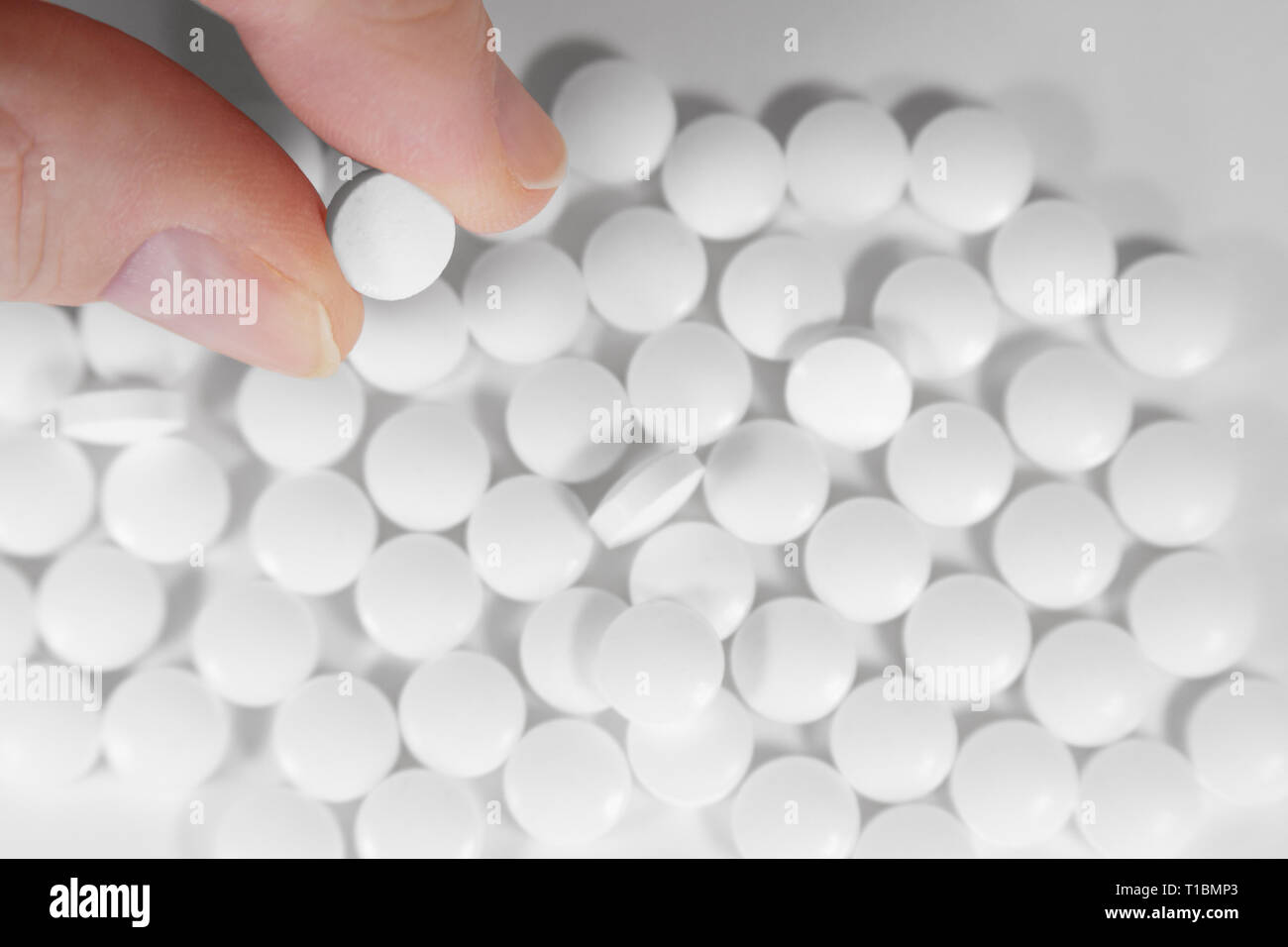 Pharmaceuticals on a white back ground. Man picks one pill from the ...