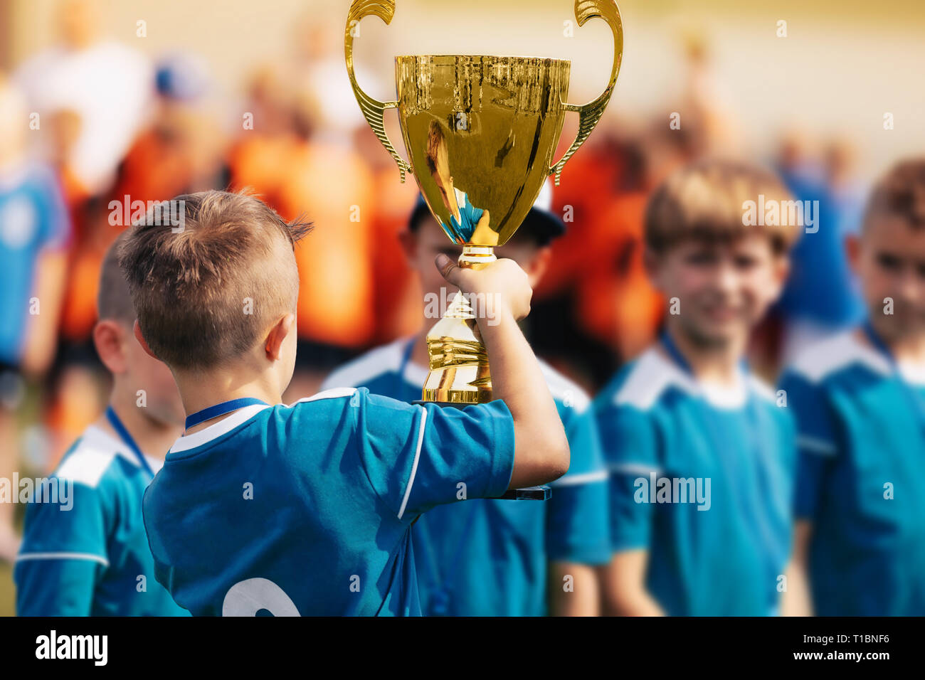 Boy holding golden trophy and celebrating sport success with team Stock ...