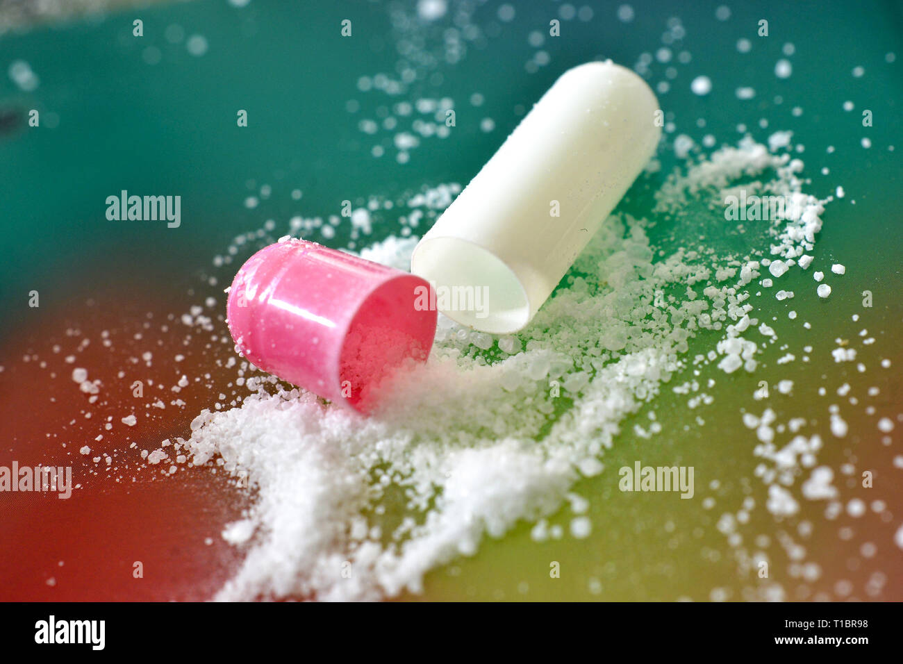 powder of an open capsule on a smartphone screen with logo of facebook ...