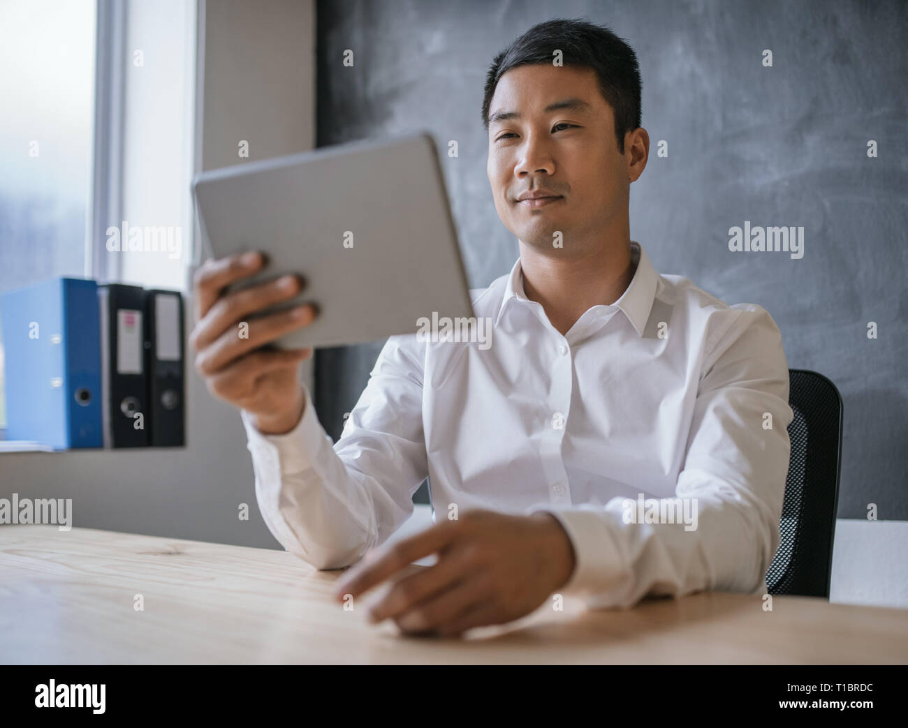 Happy asian man sitting workplace hi-res stock photography and images ...