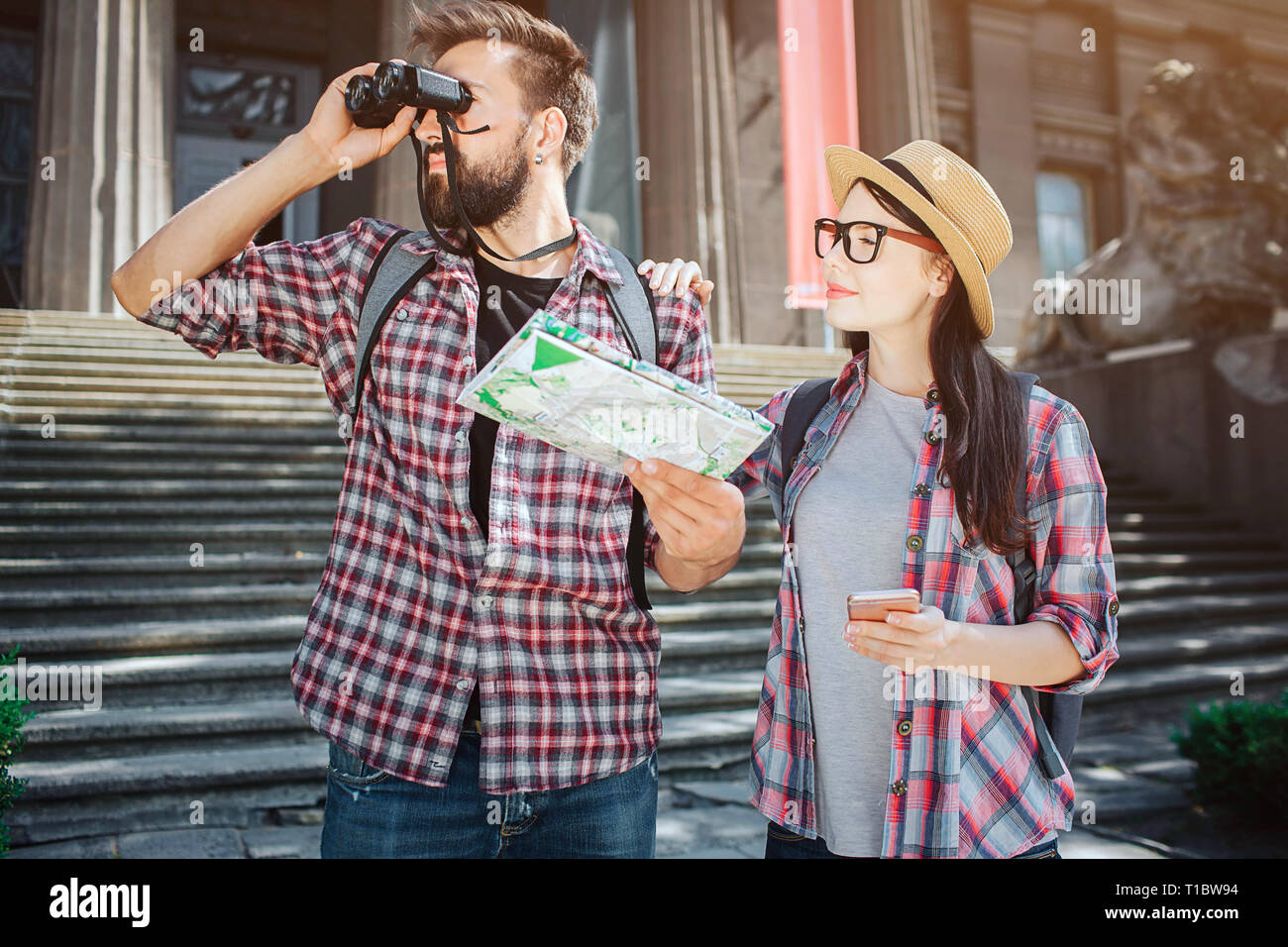 Explorer stand in front and look in binoculars. He holds map in hand ...