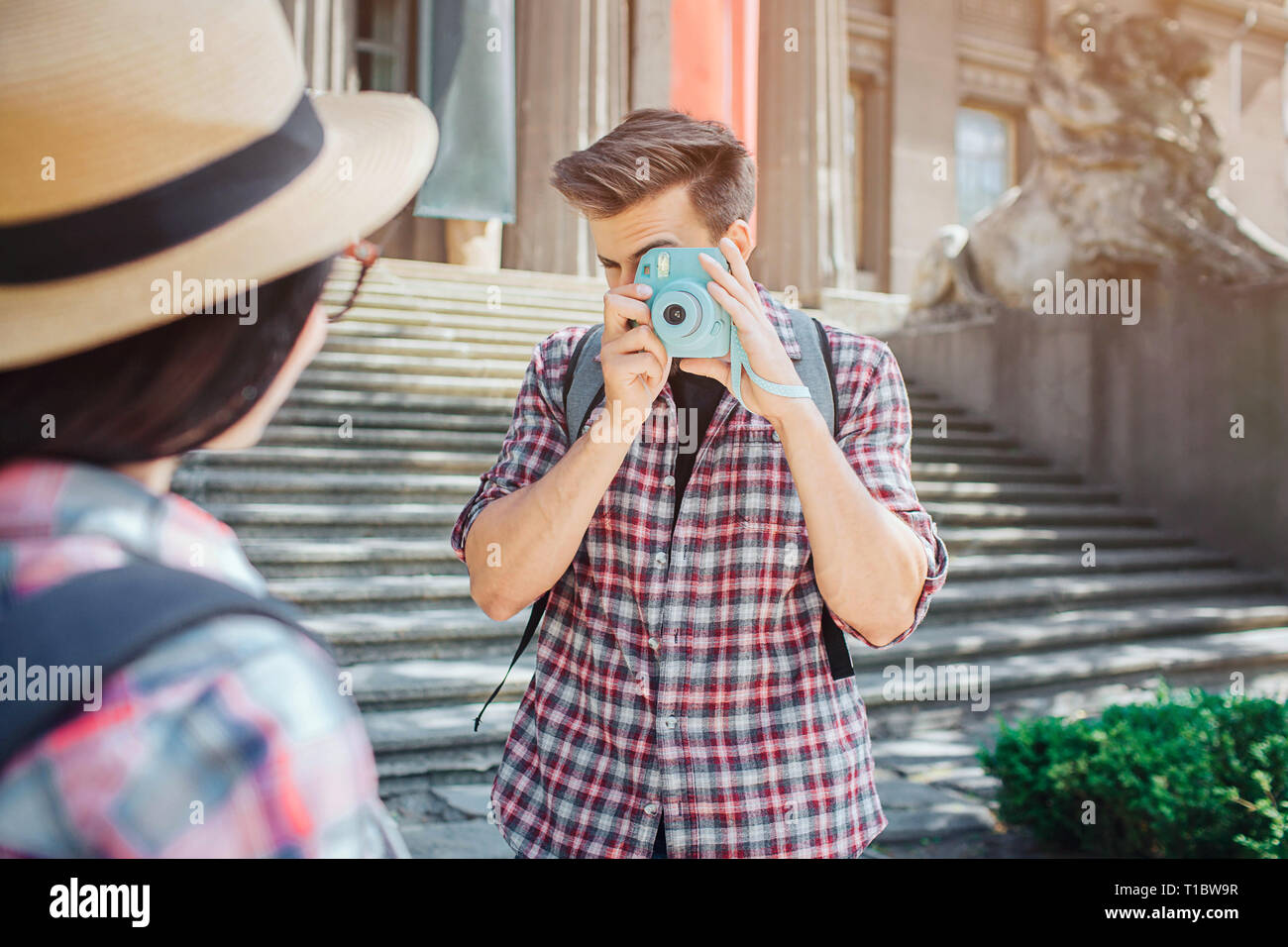 Picture of man standing and taking picture of young woman through ...